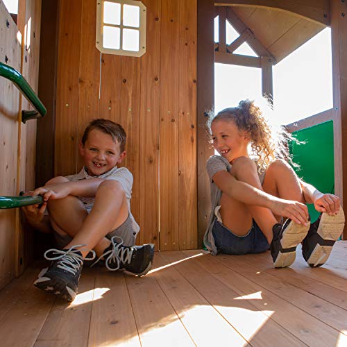 Backyard Discovery Skyfort All Cedar Swing Set, Elevated Covered Wood Roof Clubhouse with Bay Windows, 2 Belt Swings, Web Swing, 10ft Wave Slide, 5 ft Tube Slide, Covered Picnic Table, 5 ft Rock Wall