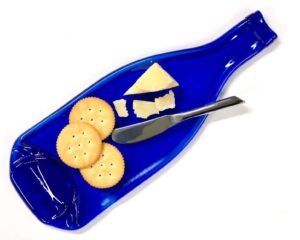 melted wine bottle cheese tray with cheese spreader in blue glass