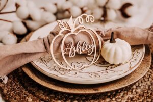 customized pumpkin name tags for thanksgiving, personalized hollowed out wooden place cards for fall, halloween table decor, cursive laser cut seating cards