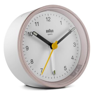 braun classic analogue alarm clock with snooze and light, quiet quartz movement, crescendo beep alarm in white and rose, model bc12pw.