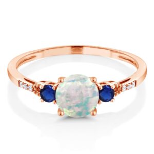 Gem Stone King 10K Rose Gold White Simulated Opal Blue Created Sapphire and White Diamond Accent 3-Stone Engagement Ring For Women (0.95 Cttw, Round Cabochon 6MM, Gemstone October Birthstone, Size 9)