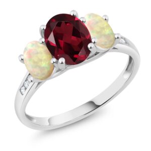 10k white gold red rhodolite garnet white ethiopian opal and white diamond oval 3-stone engagement ring for women (1.99 cttw, gemstone january birthstone, available in size 5, 6, 7, 8, 9)