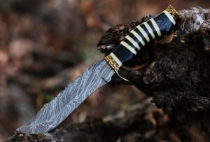 12.5 inch long hunting knife, collectible knife, scale is made of camel bone and dollar wood, embellished with engraved brass finger guard and pommel, hand forged twist pattern damascus steel blade, comes with leather sheath