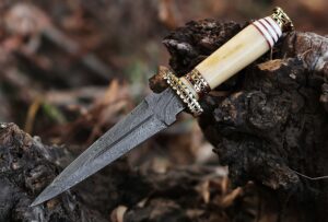 12.5 inch long hunting knife, collectible knife, natural camel bone scale embellished with engraved brass finger guard, foil work spacer and pommel, hand forged twist pattern damascus steel blade, comes with leather sheath