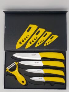 serrated black ceramic knife set with 5" serrated knife. includes 3”, 4”, 5”, 6” ceramic knives, matching sheaths and a matching vegetable peeler in a black gift box