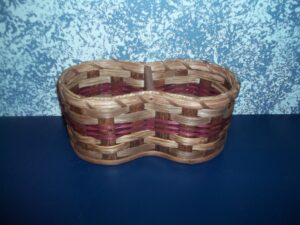 amish handmade home and garden peanut basket. this handmade basket was designed to put nuts in one side and empty the shells in the other side. this basket is in the shape of a peanut and will make a great conversation piece. colors may vary (black, red,