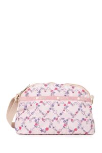 lesportsac heart half moon crossbody bag, style 3468/color f705, pink, purple & white flowers artfully arranged in romantic heart designs, pale pink bag, soft iridescent sheen, petite crossbody